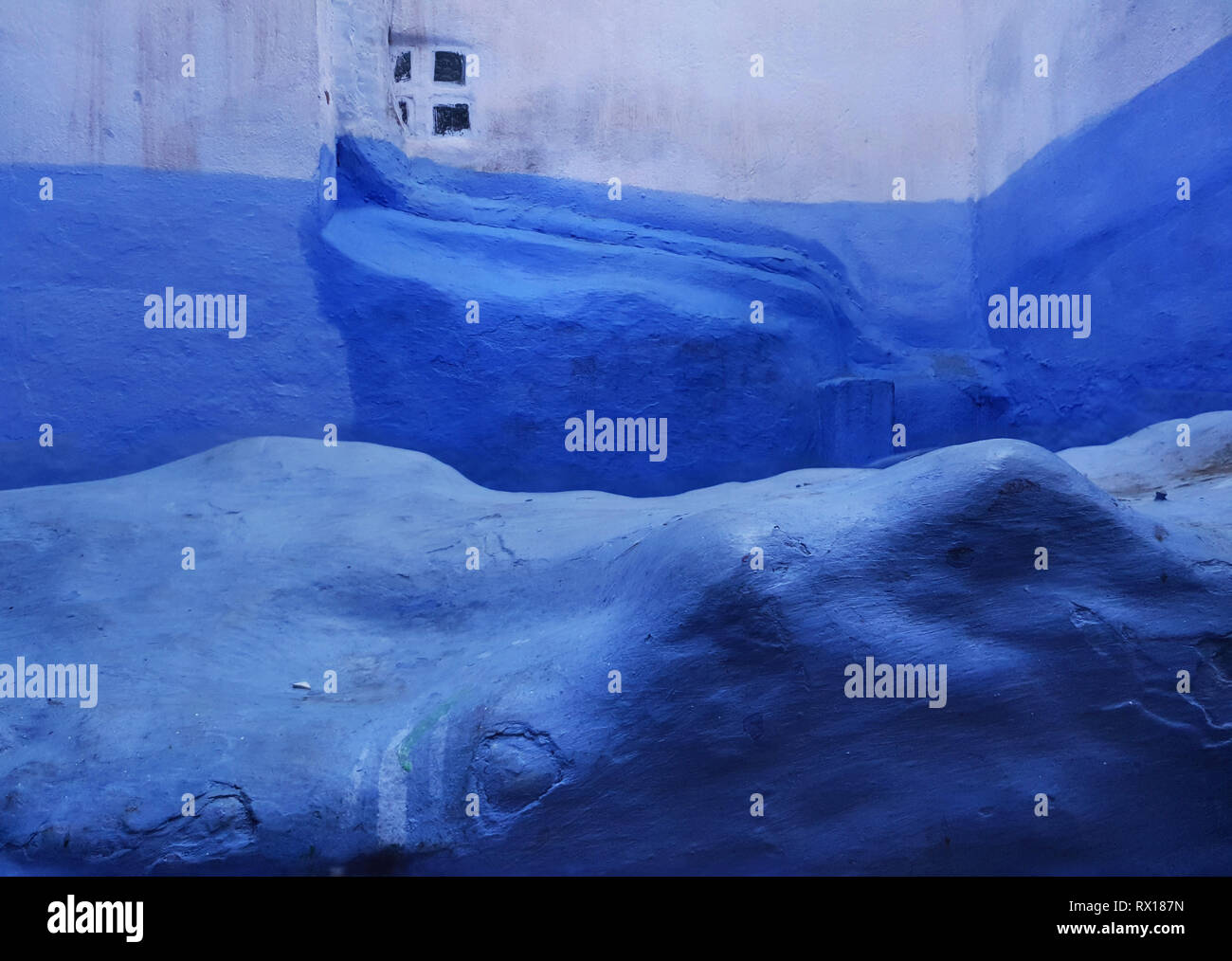 Blue bottom stone wall, white on top with smooth curves with a small ...