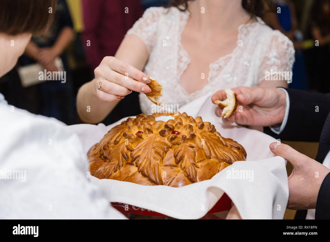 The bride and groom break the wedding loaf Stock Photo - Alamy