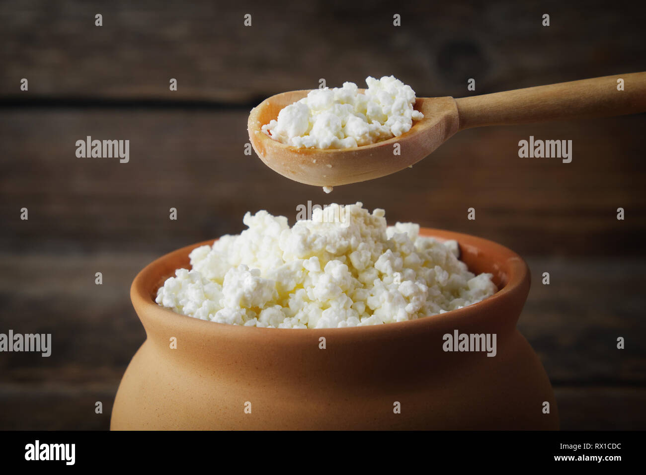 Cottage cheese in rustic vintage clay pot and wooden spoon Stock Photo ...