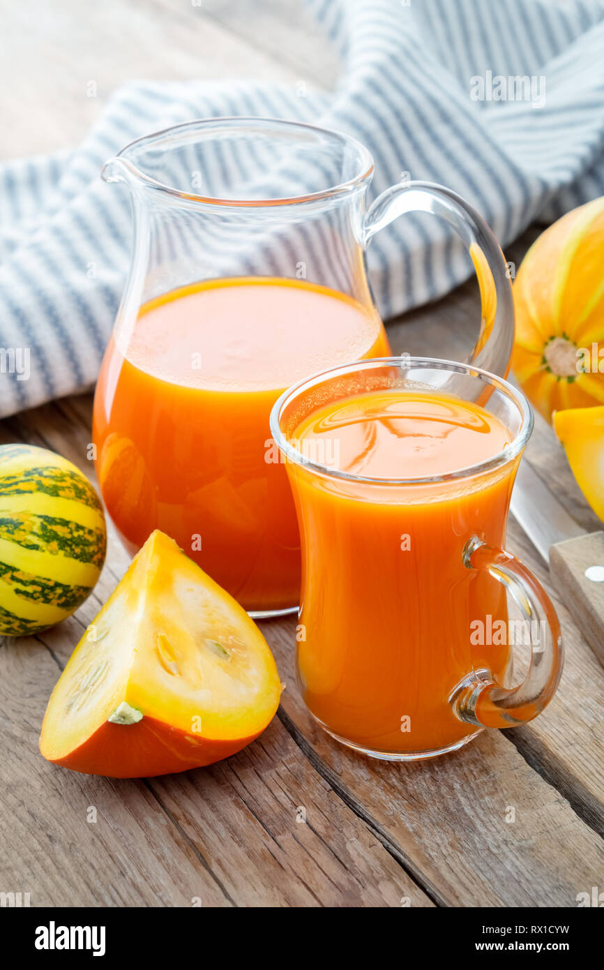 Glass jug and cup of pumpkin juice and pumpkins Stock Photo - Alamy