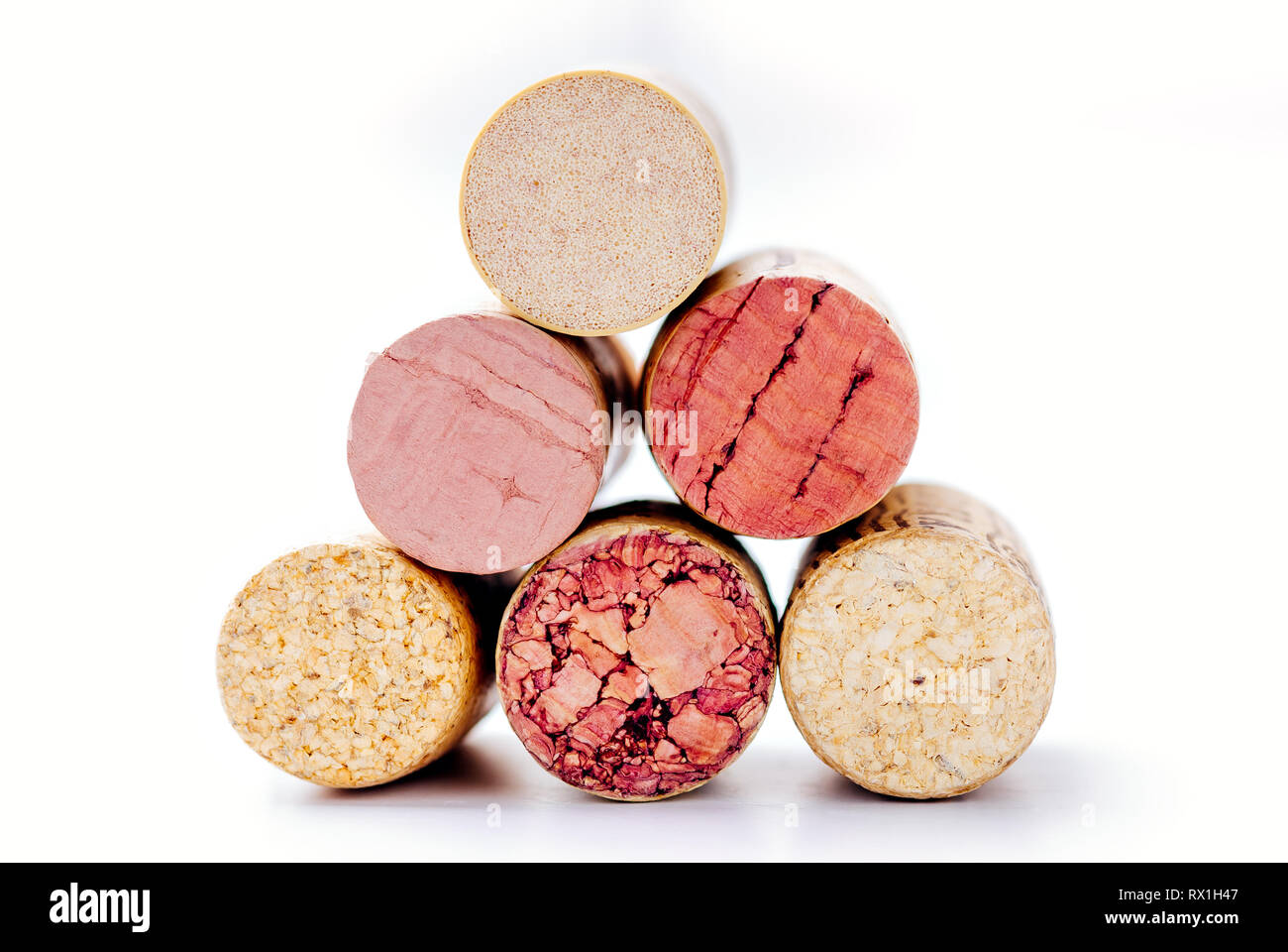 A pile of six different unscrewed wine corks on a white background ...