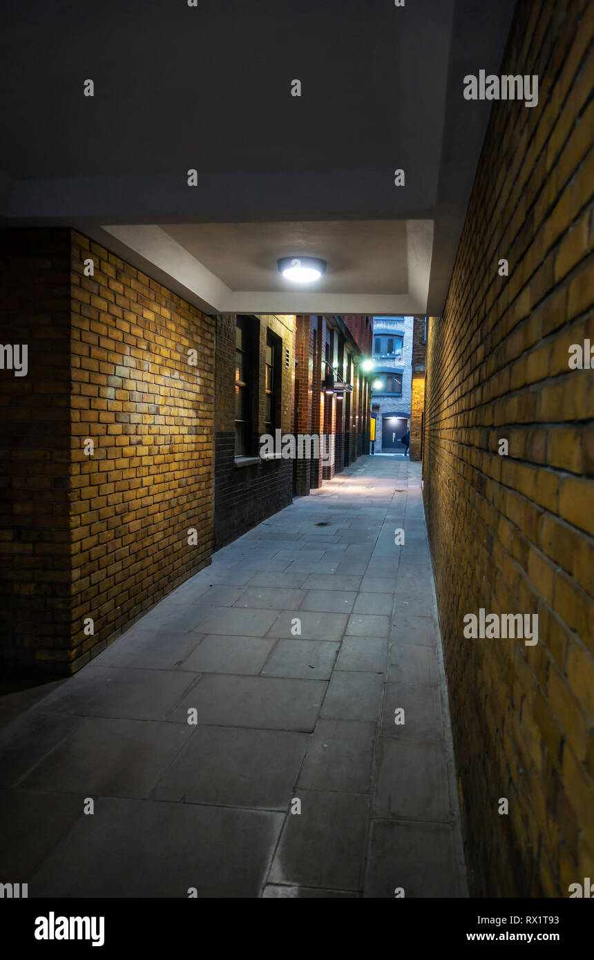 Semi dark paved passageway between buildings Stock Photo - Alamy
