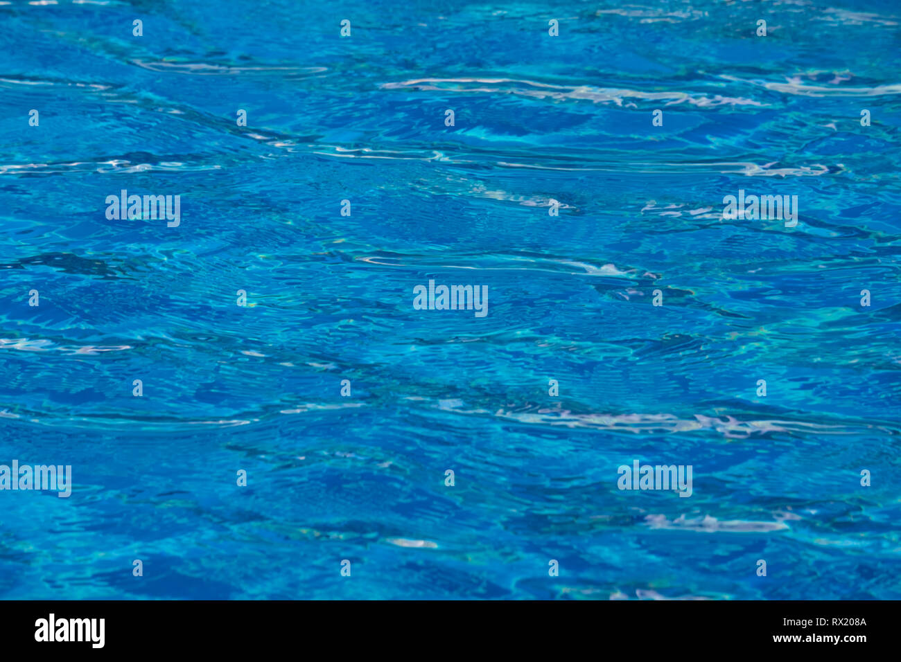 Blue and bright ripple clean water surface in swimming pool with sun ...