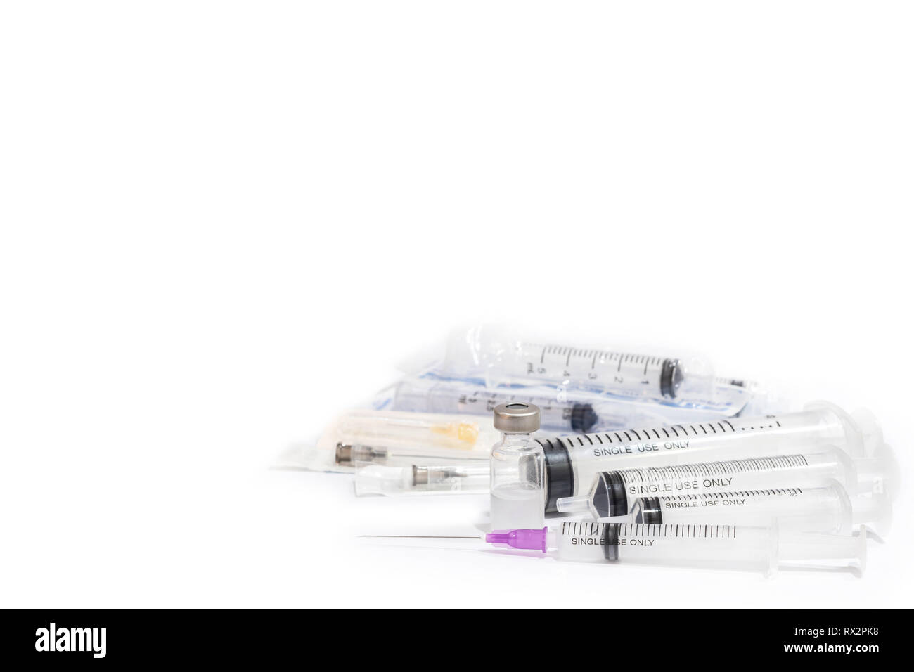 Vials with medication and injection needle isolated on white background. Multiple syringes ...