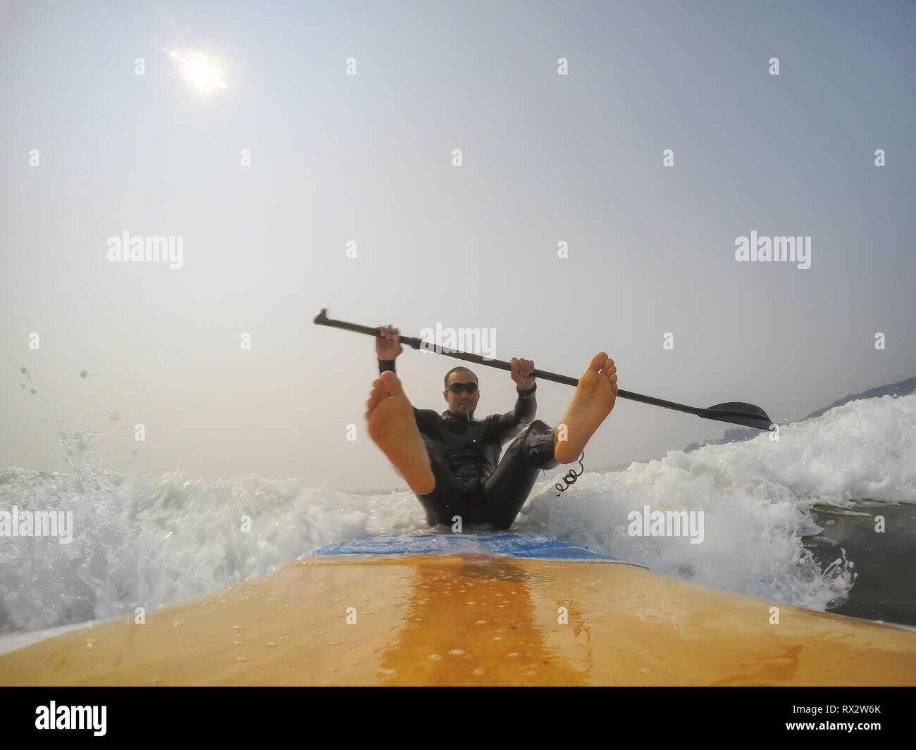 Man paddle surfer is riding a wave in the Pacific Ocean. Taken in ...