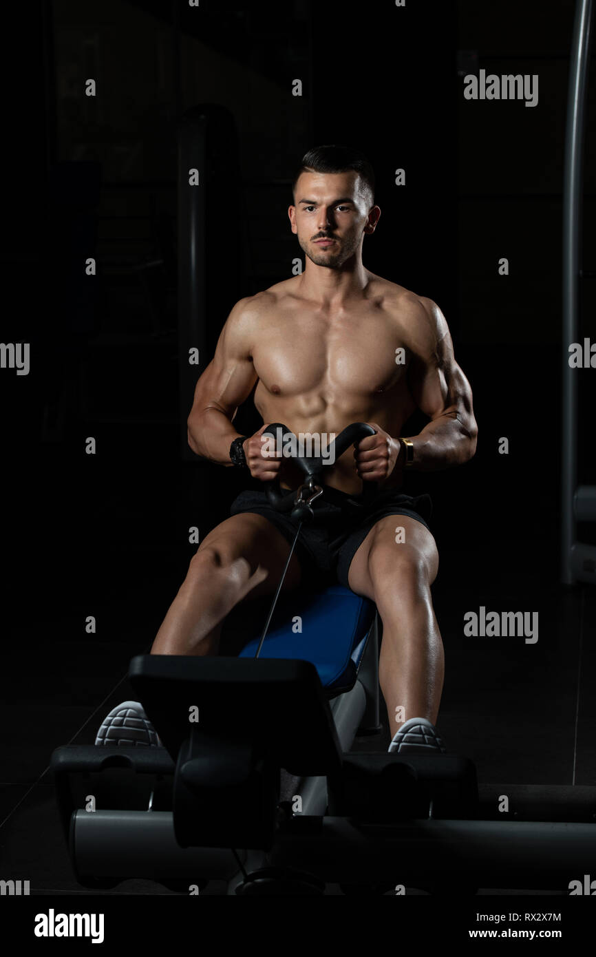 Handsome Bodybuilder Doing Heavy Weight Exercise For Back On Machine ...