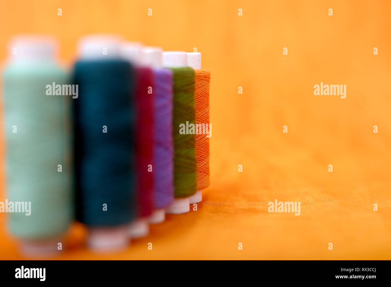 Portrait of multicolored sewing thread. Isolated on the yellow ...