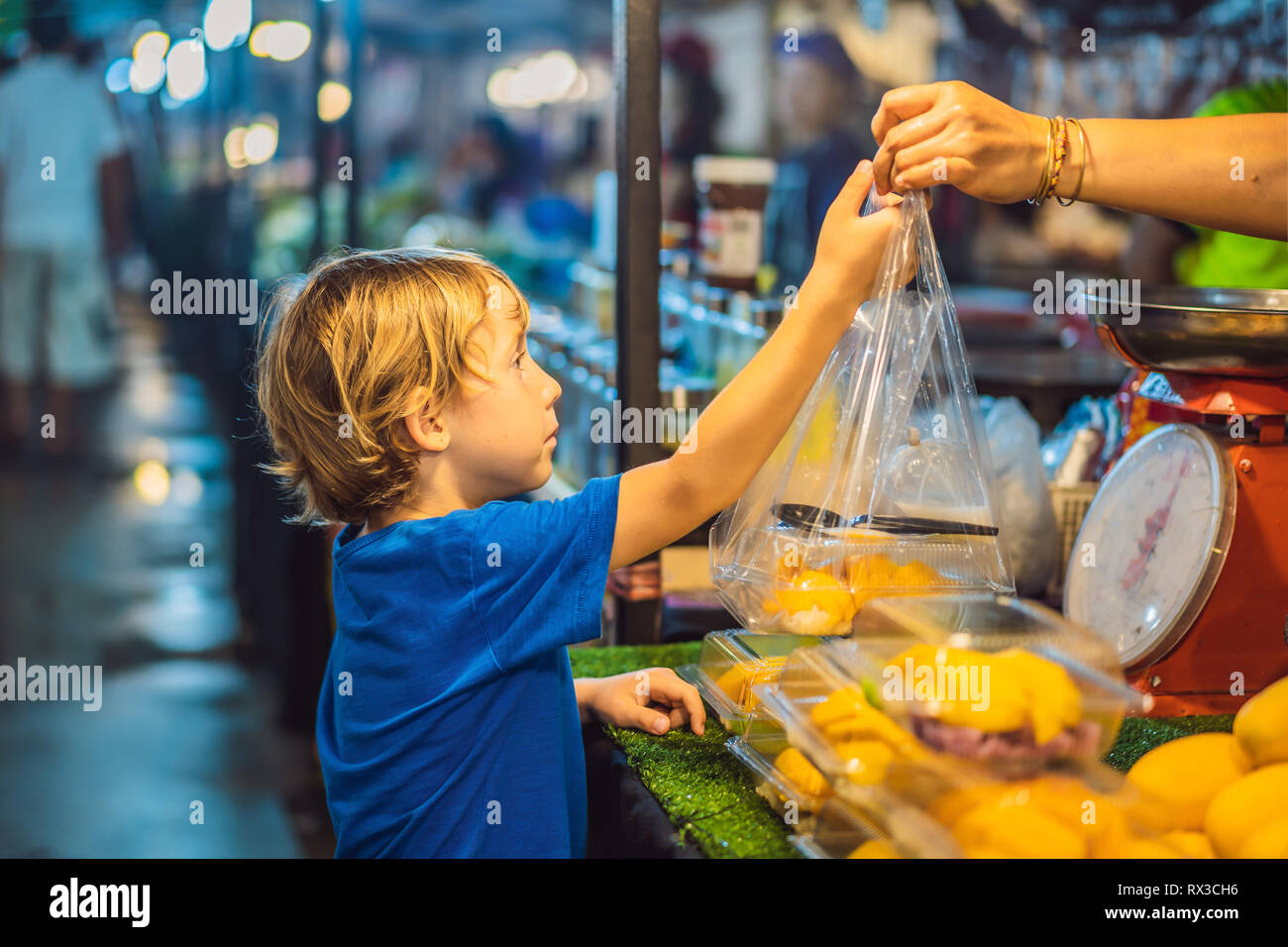 Young boy tourist on Walking street Asian food market Stock Photo - Alamy