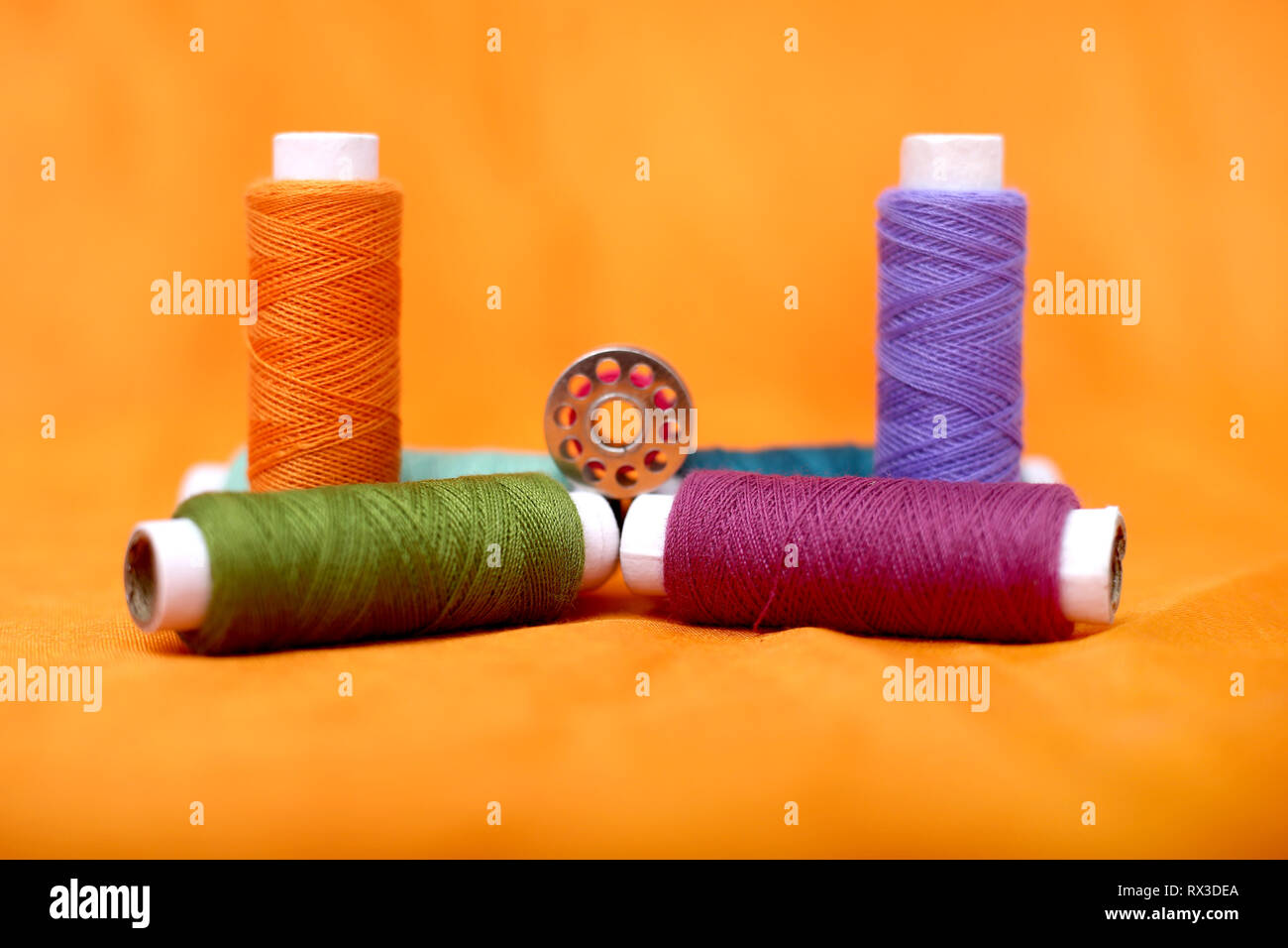 Portrait of one bobbin and sewing thread . Isolated on the yellow ...