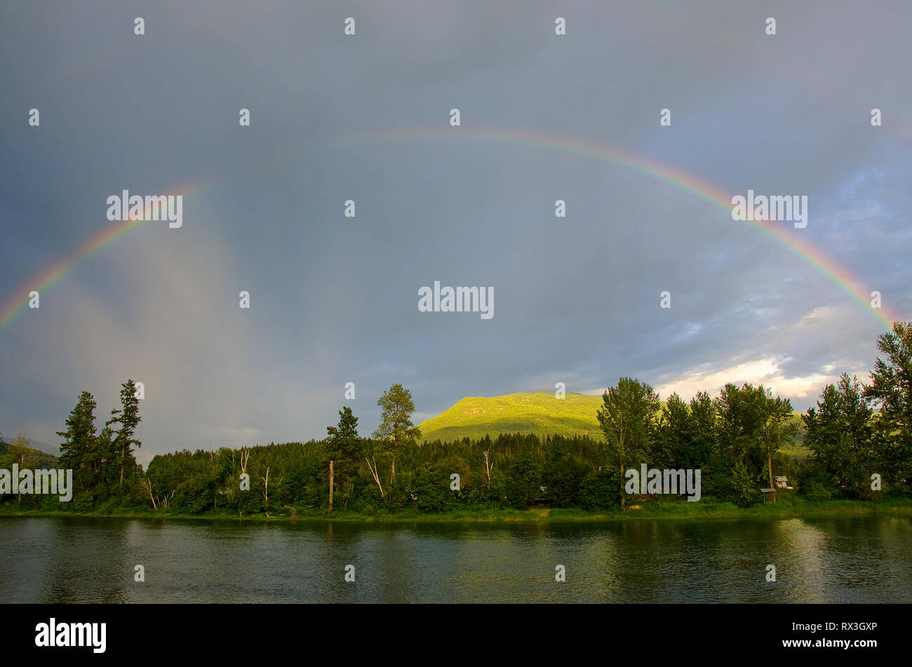 Rainbow appears over the shuswap river in spring hi-res stock ...