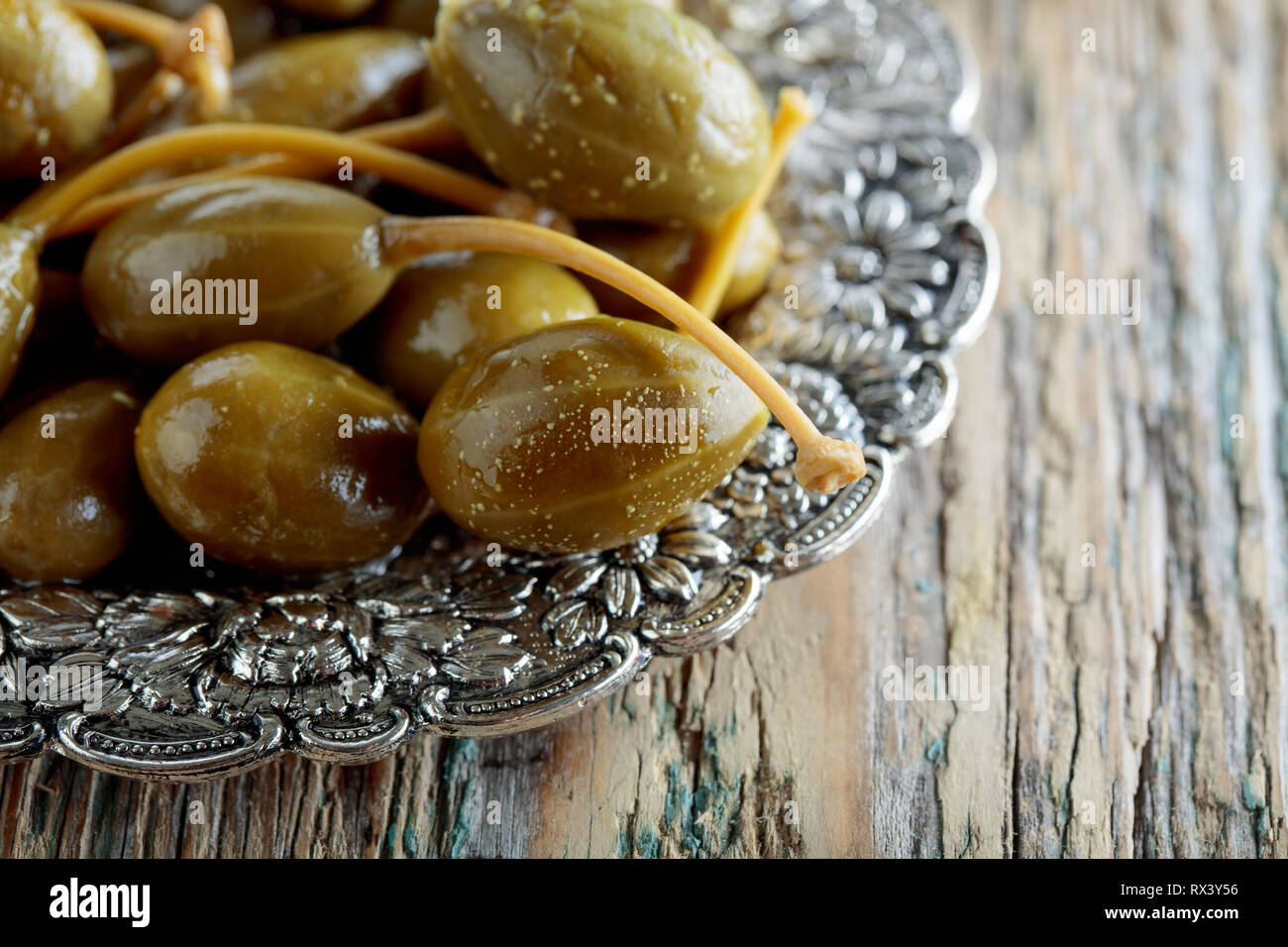 Pickled caper berries in metal dish . Edible fruits of Capparis ...