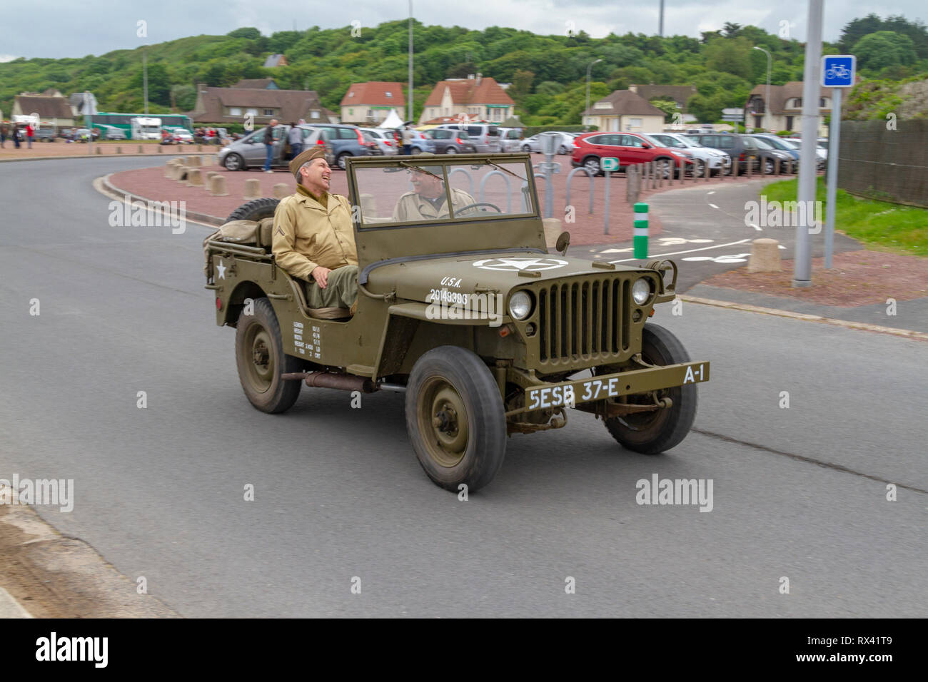 Re-enactors in a World War II American jeep on the seafront of Omaha ...