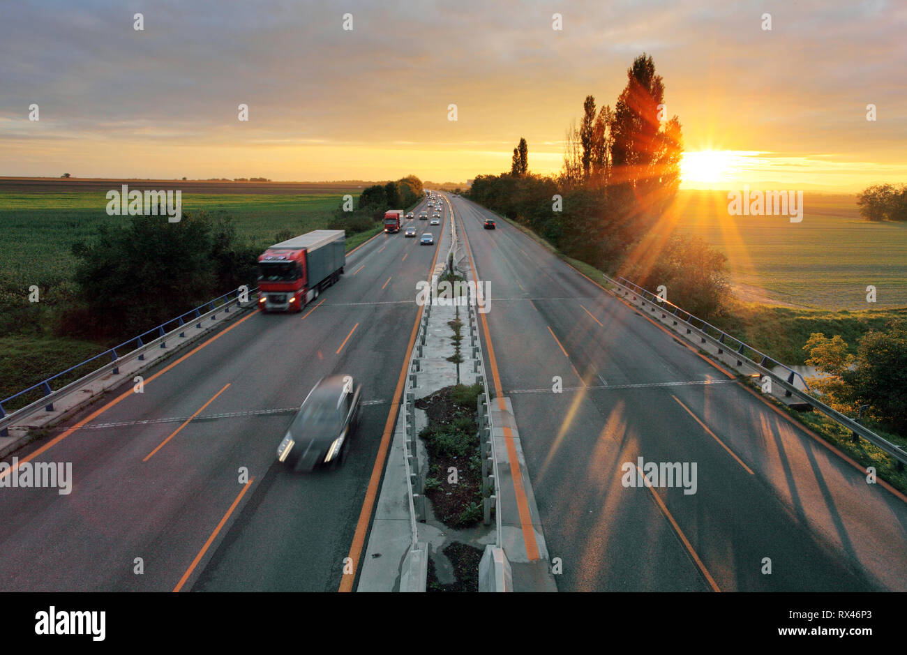 Highway with car at sunset Stock Photo - Alamy