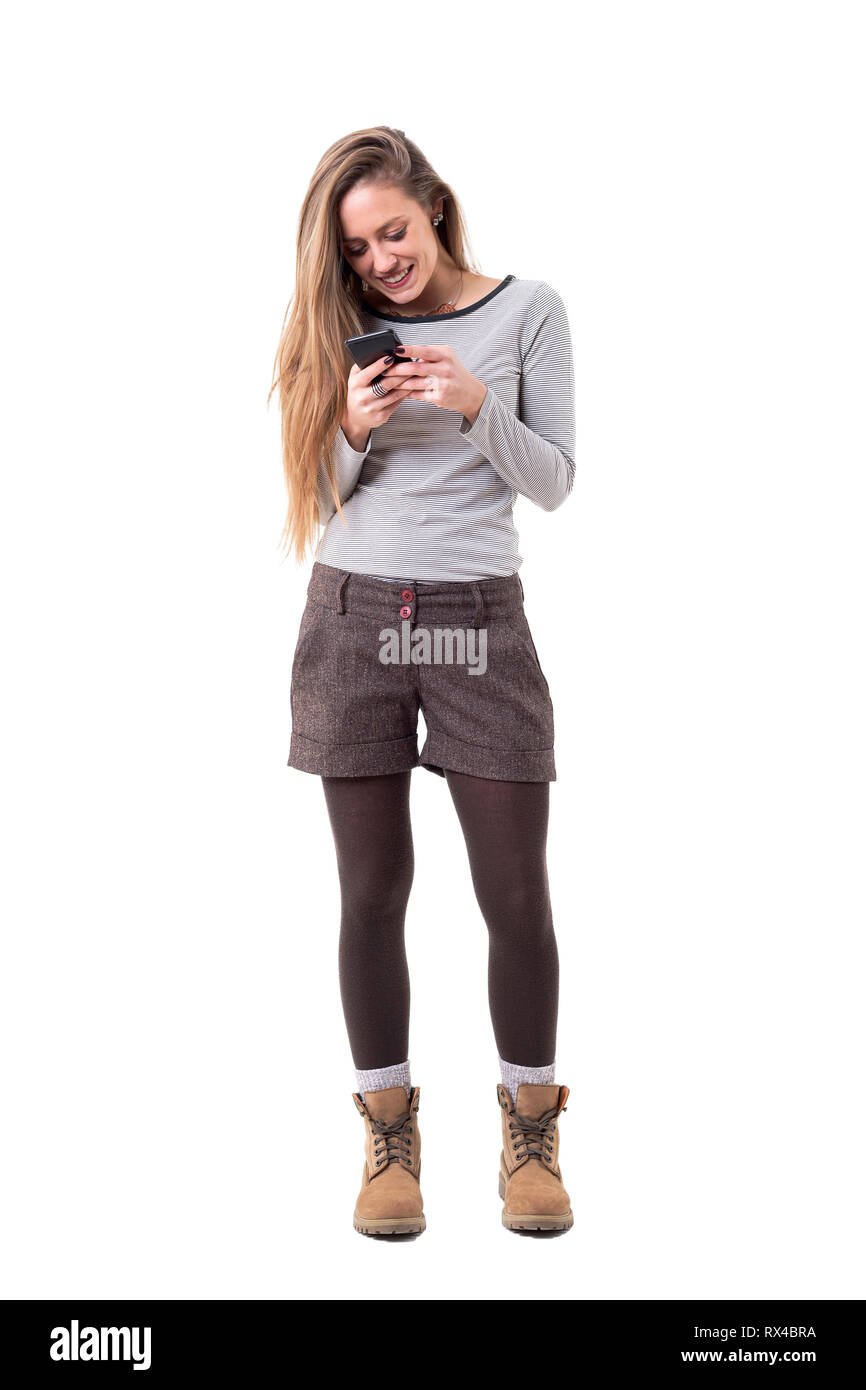 Happy excited smiling woman typing message on mobile phone. Full body ...