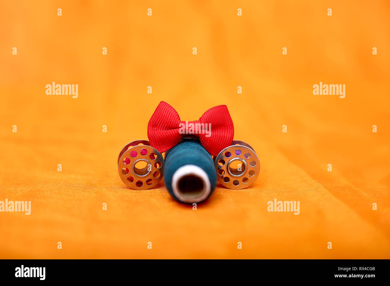 Picture of red bow, sewing threads and bobbin. Isolated on the red ...