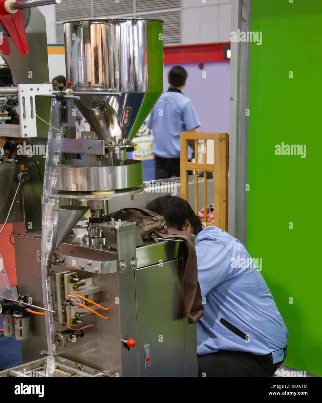 Worker repair vertical sauce filling and packing machine Stock Photo ...