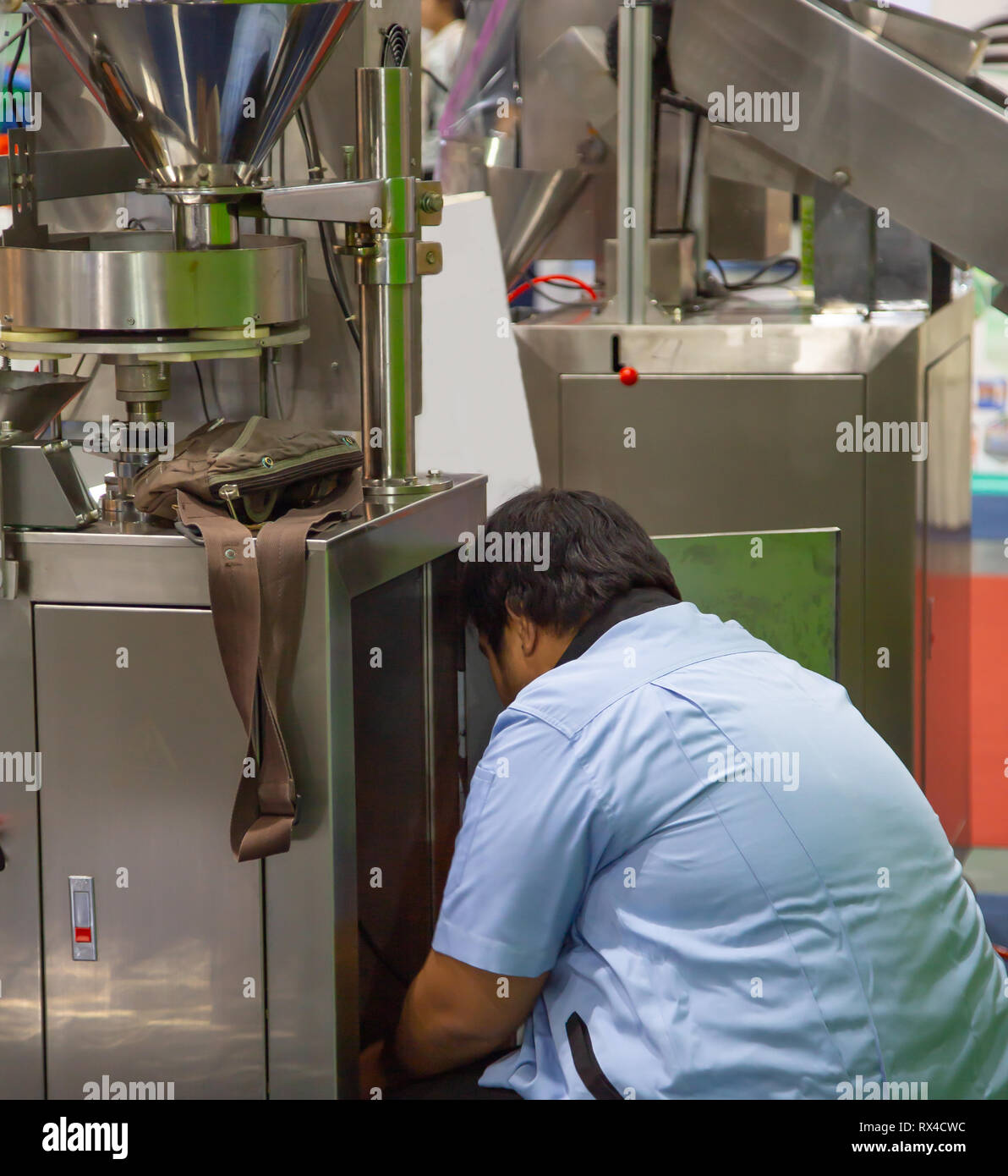 Worker repair vertical sauce filling and packing machine Stock Photo ...