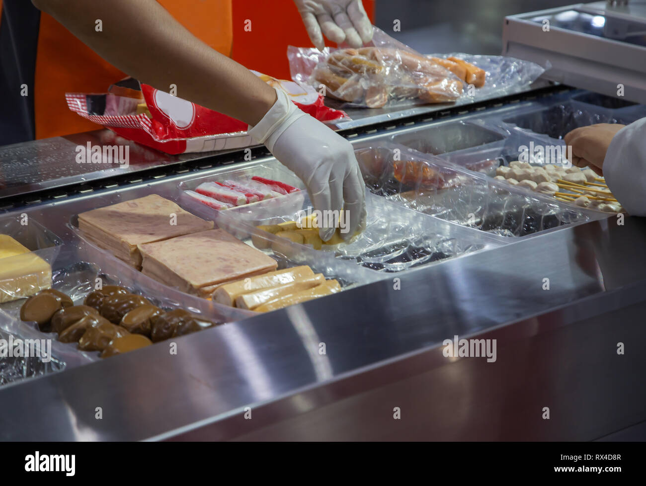 Worker put food in plastic tray for packing food in machine Stock Photo ...