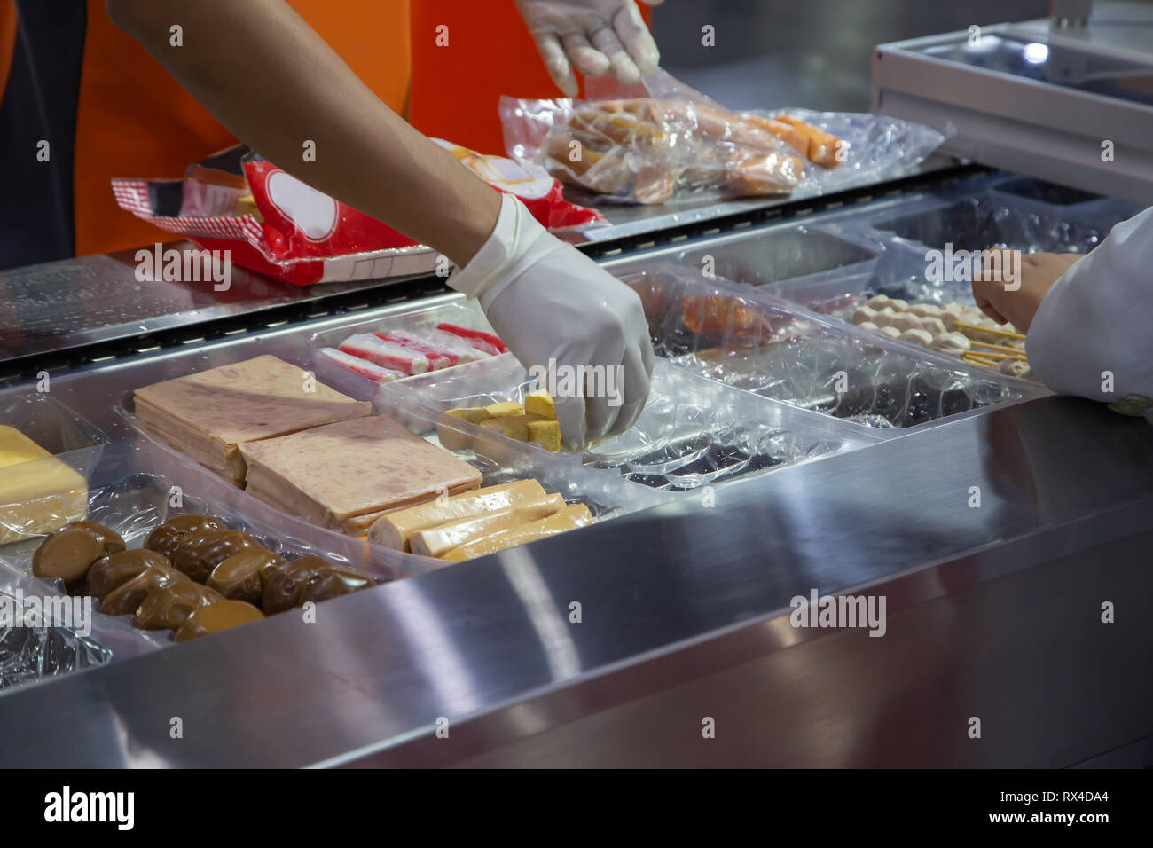 Worker put food in plastic tray for packing food in machine Stock Photo ...