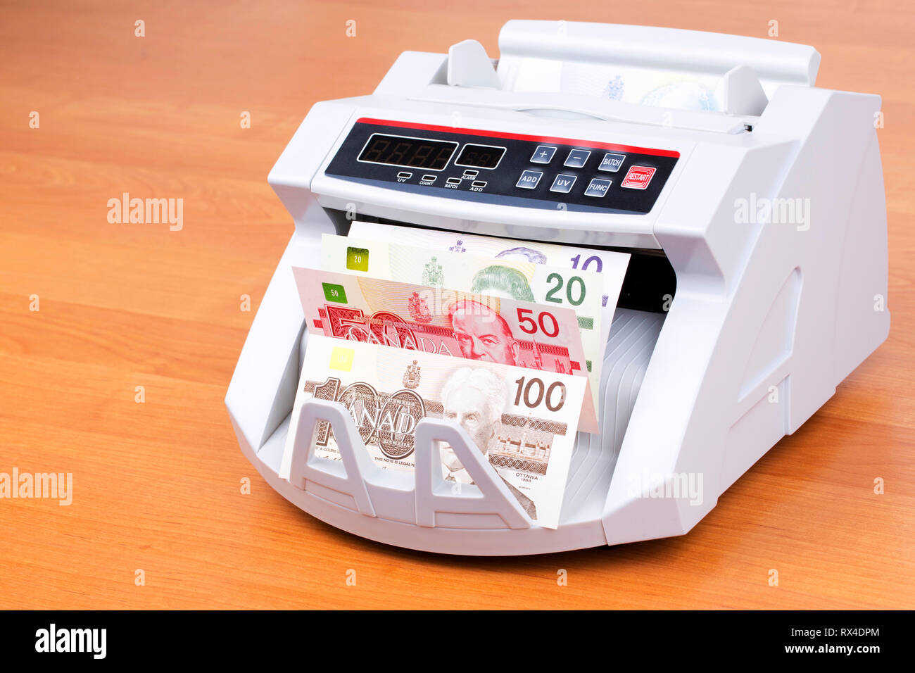 Canadian Dollars in a counting machine Stock Photo - Alamy