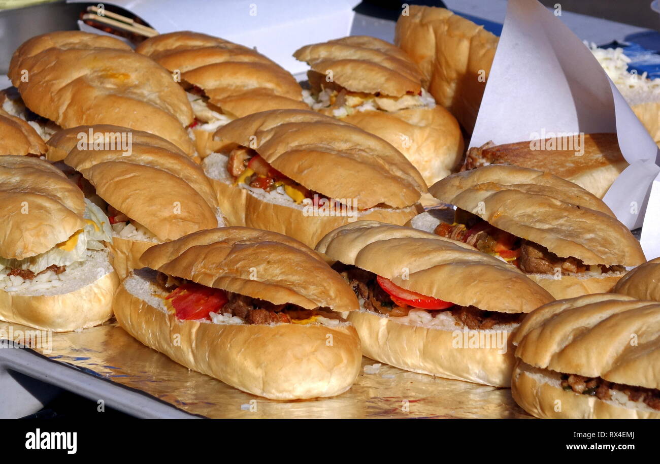 A street vendor sells sandwiches with roasted meat, tomatoes and ...