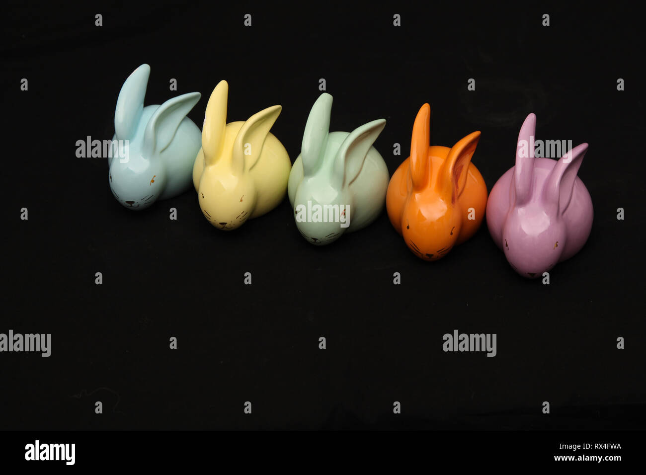 Colourful ceramic rabbits on a black background Stock Photo - Alamy