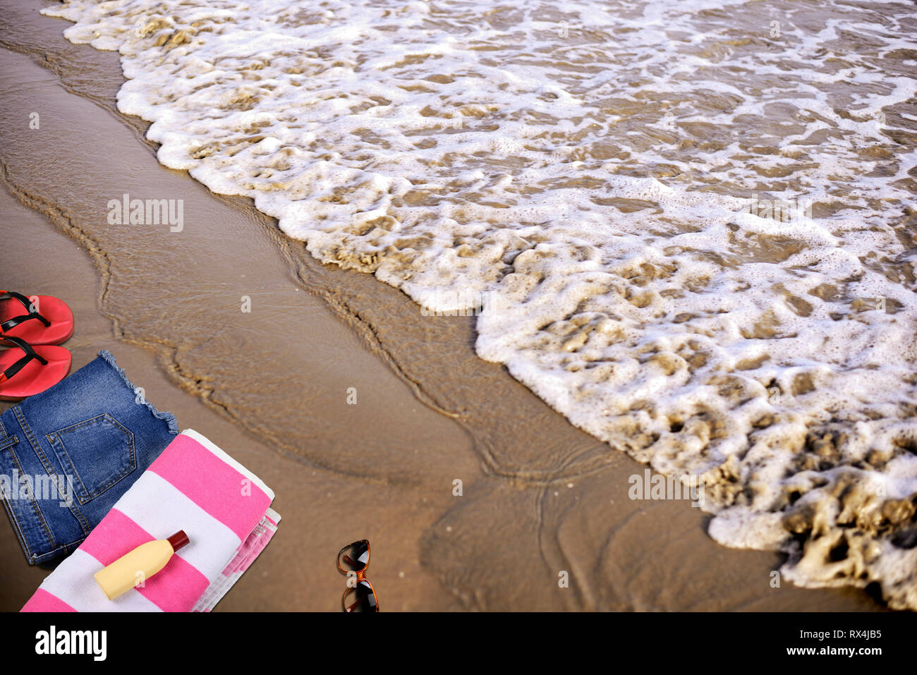 Summer Beach accessories laying on sand in empty sea beach Stock Photo ...
