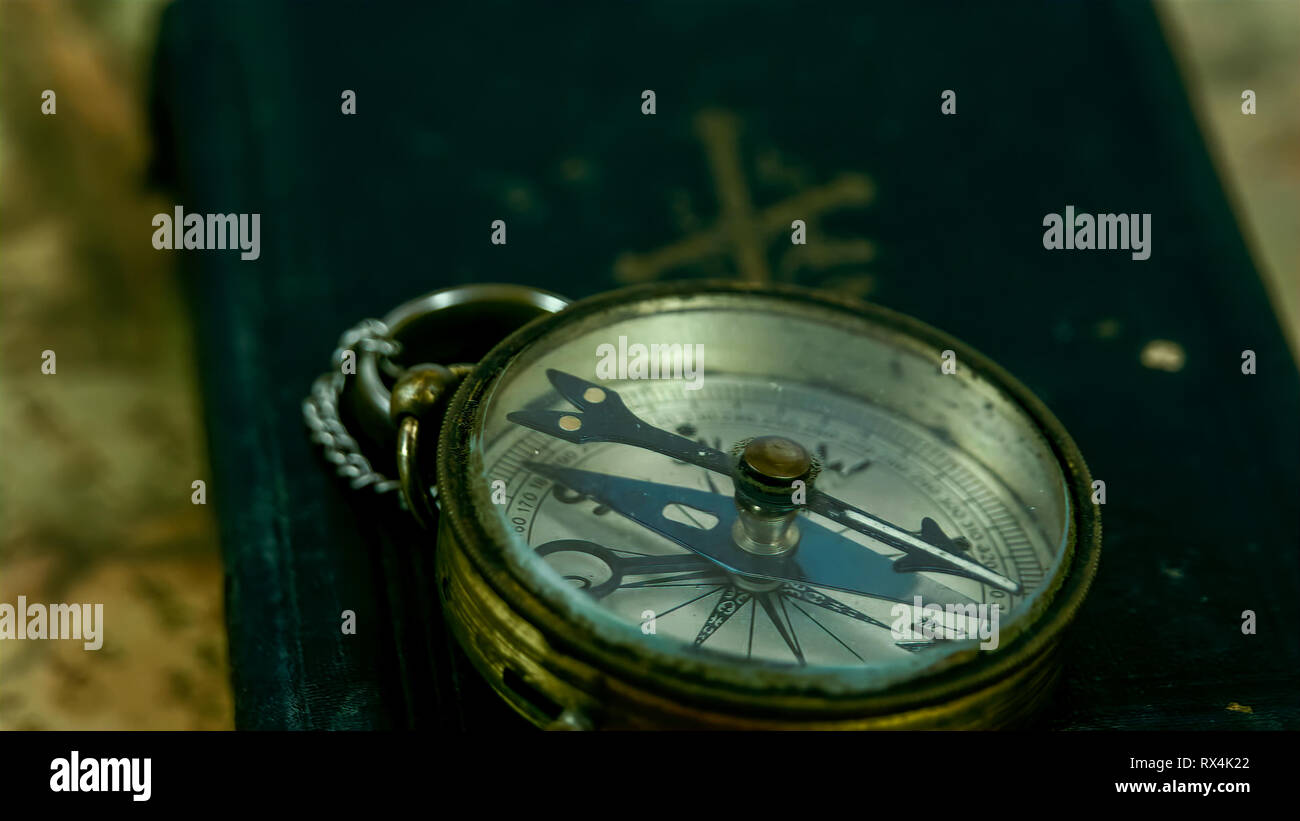 A compass pointing to North and the bible. The compass is on top of a ...