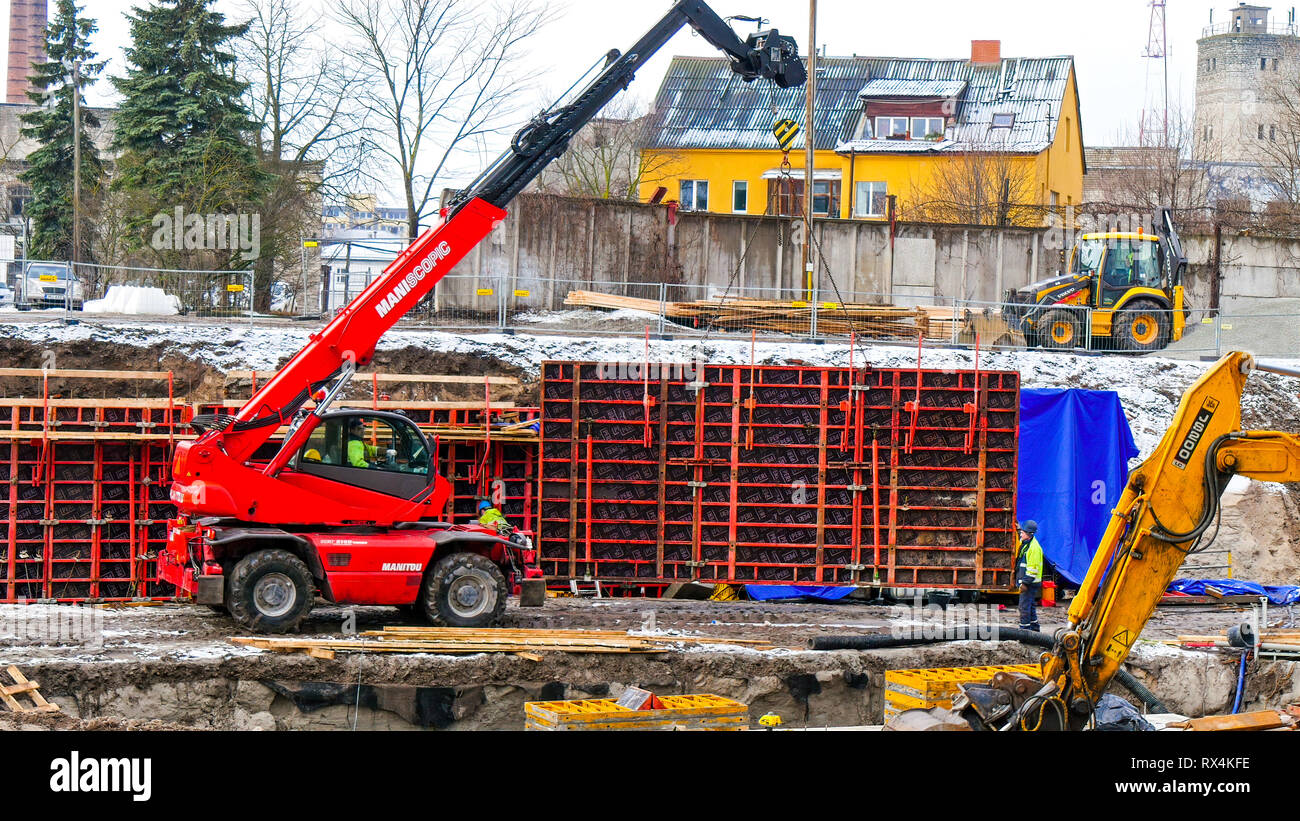 Red crane truck carrying a load of metals. The crane is carrying a red ...