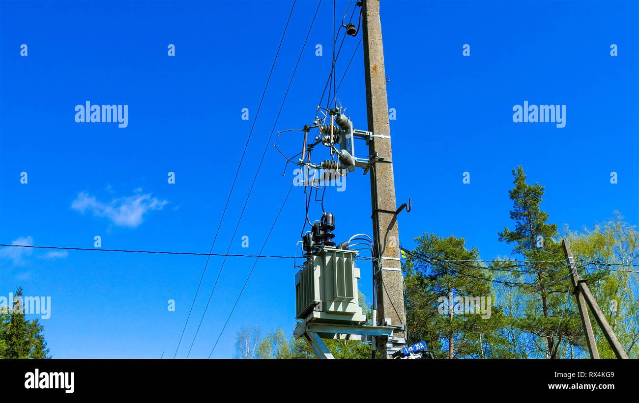 An electricity post with big transformers. It is located on the side of ...