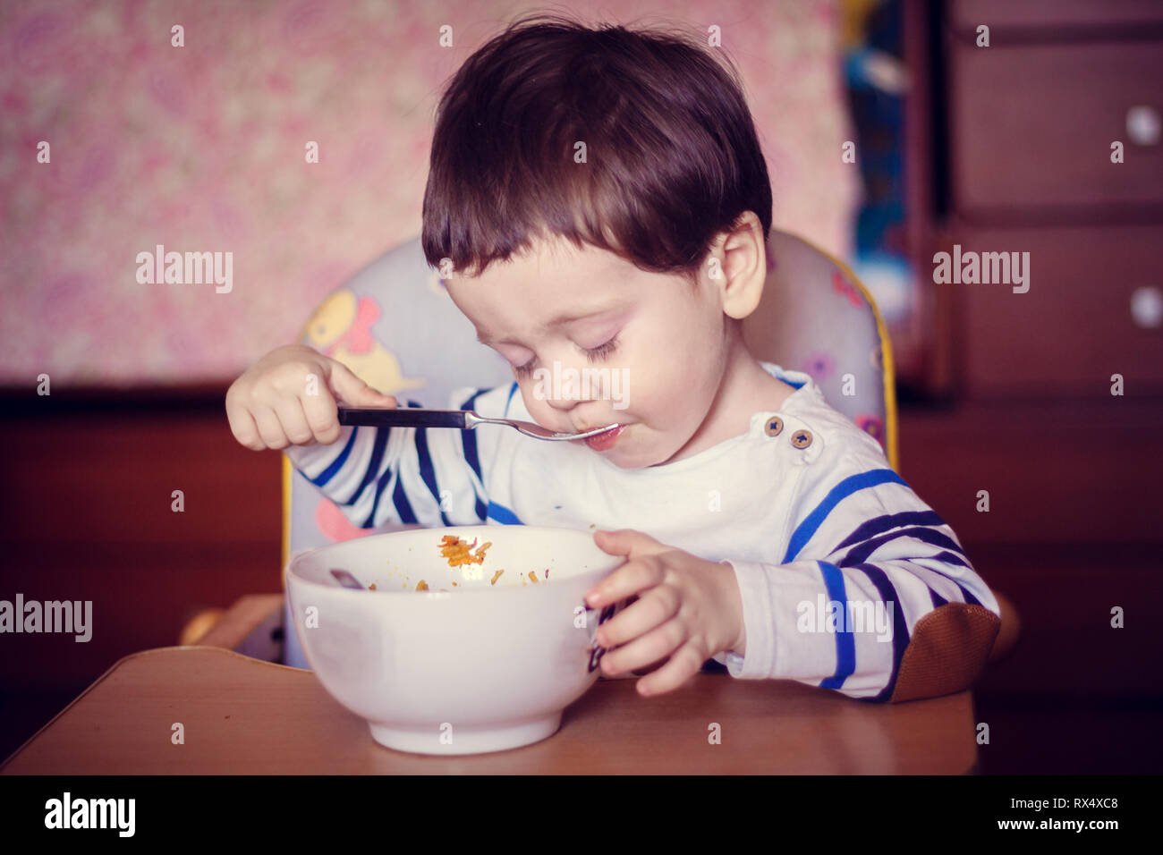 The boy eats himself from the plate. An independent child. The child ...