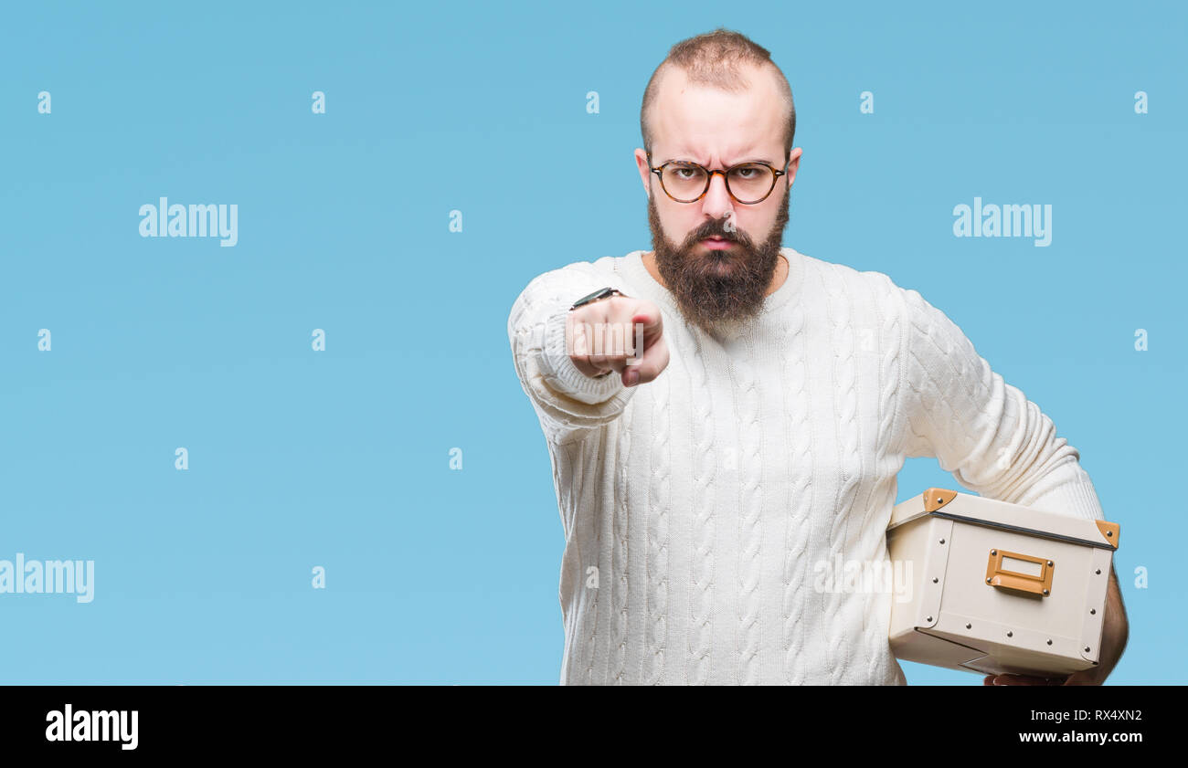 Young hipster man wearing glasses, moving holding moving box over ...