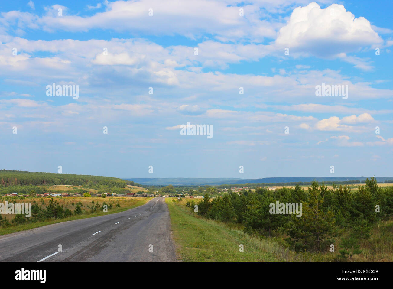 Landscape with receding road and the Russian hinterland village near ...