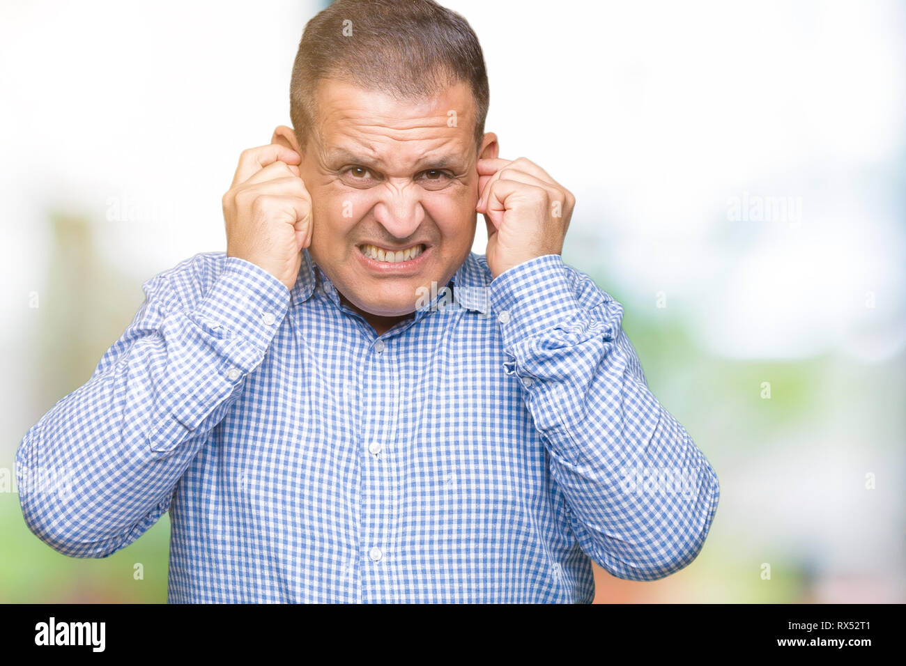 Middle age arab business man over isolated background covering ears ...