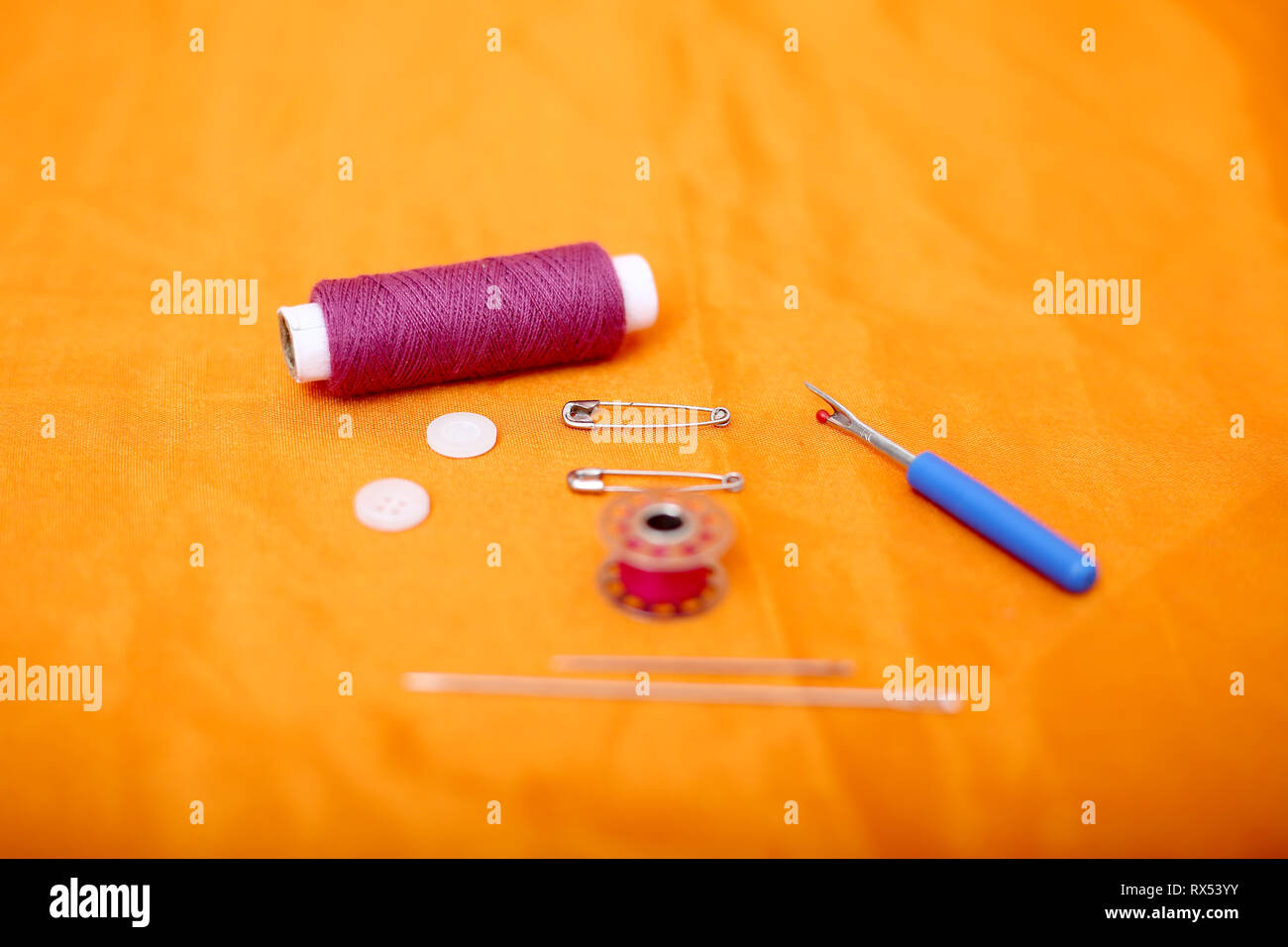 Picture of one sewing thread, needle, bobbin, button, safety pin and ...