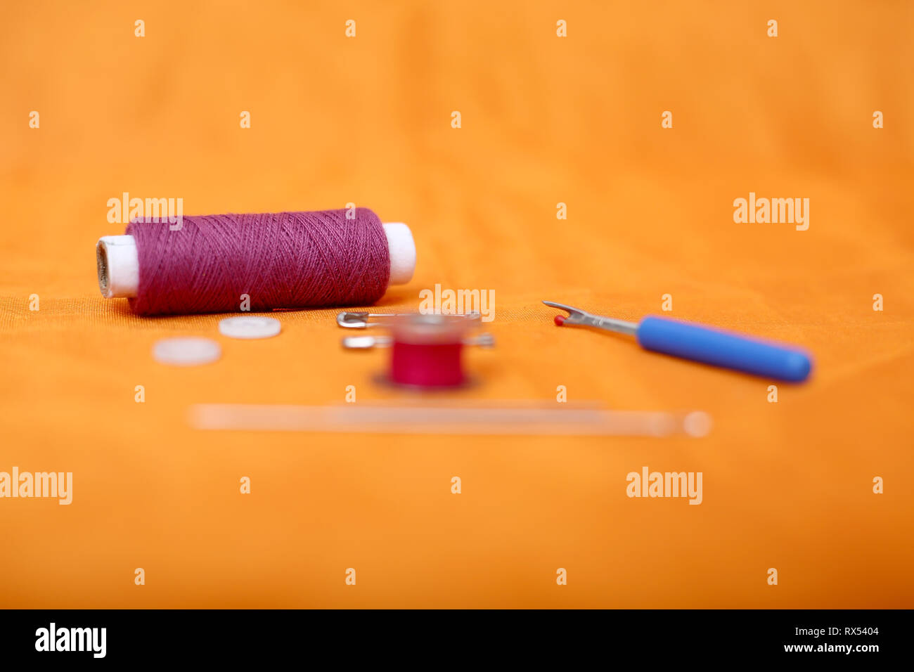 Portrait of one sewing thread, needle, bobbin, button, safety pin and ...