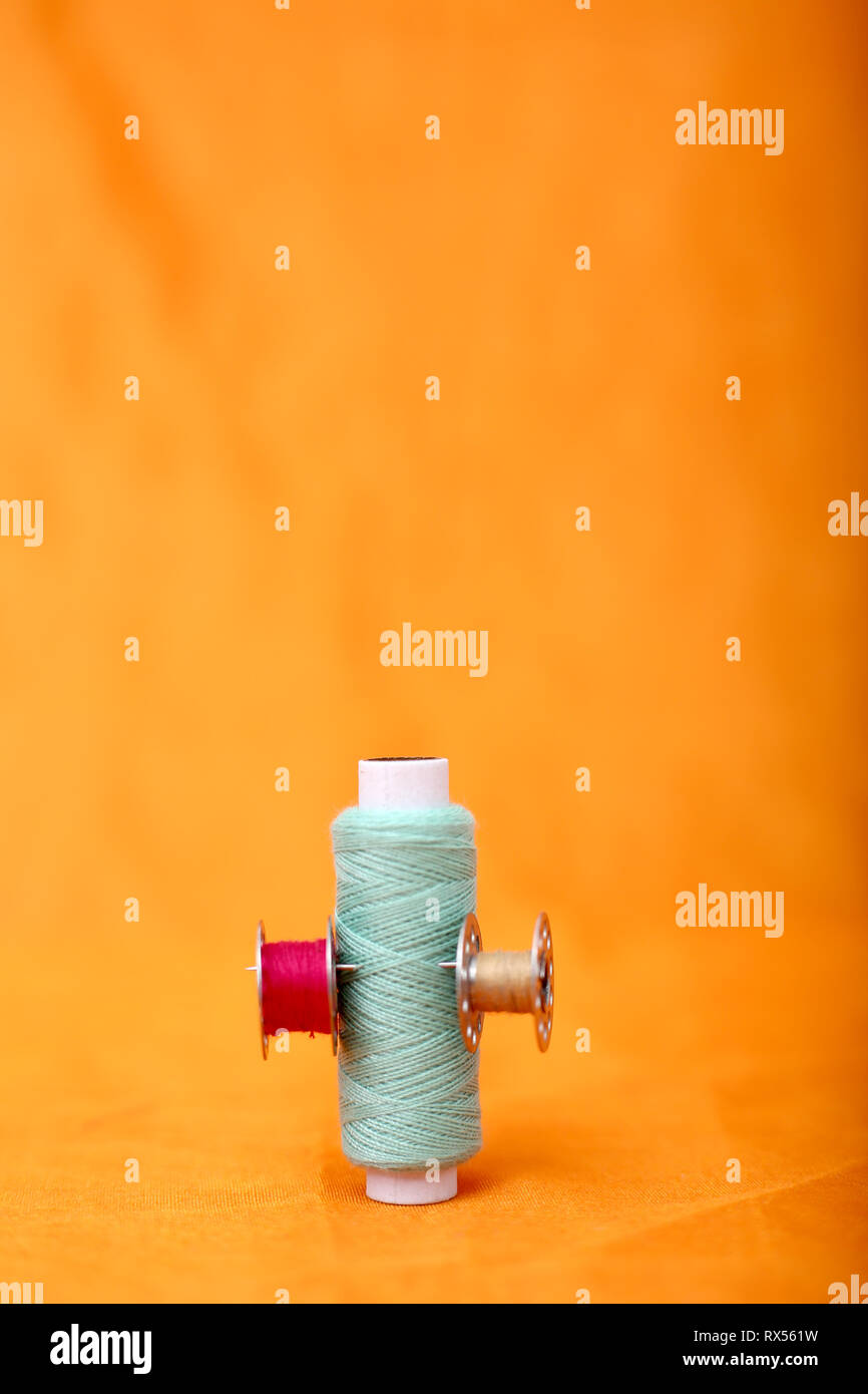 Picture of one sewing thread and bobbin. Isolated on the yellow ...