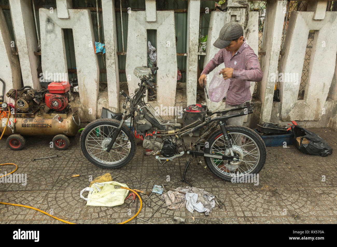 Street mechanic at work in Ho Chi Minh, Vietnam Stock Photo - Alamy