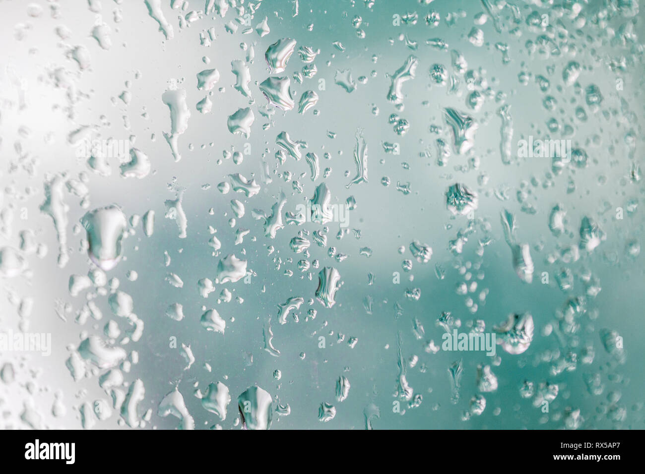 Raindrops on a windowpane with blue background Stock Photo - Alamy