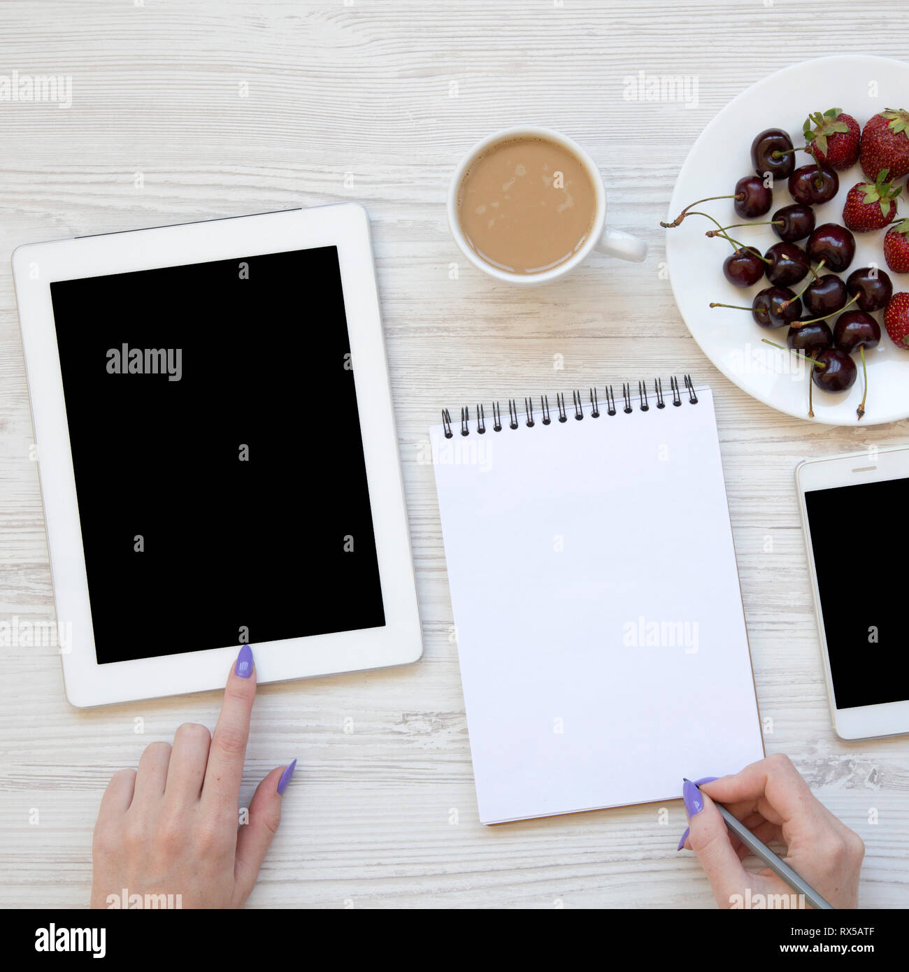 Modern feminine workspace with female hands, smartphone, tablet ...