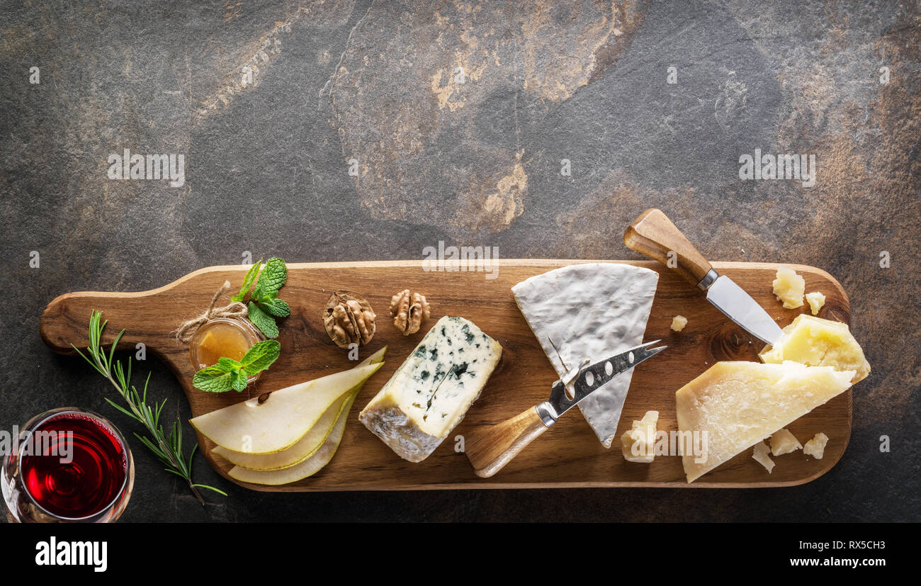 Cheese platter with organic cheeses, fruits, nuts and wine on stone ...