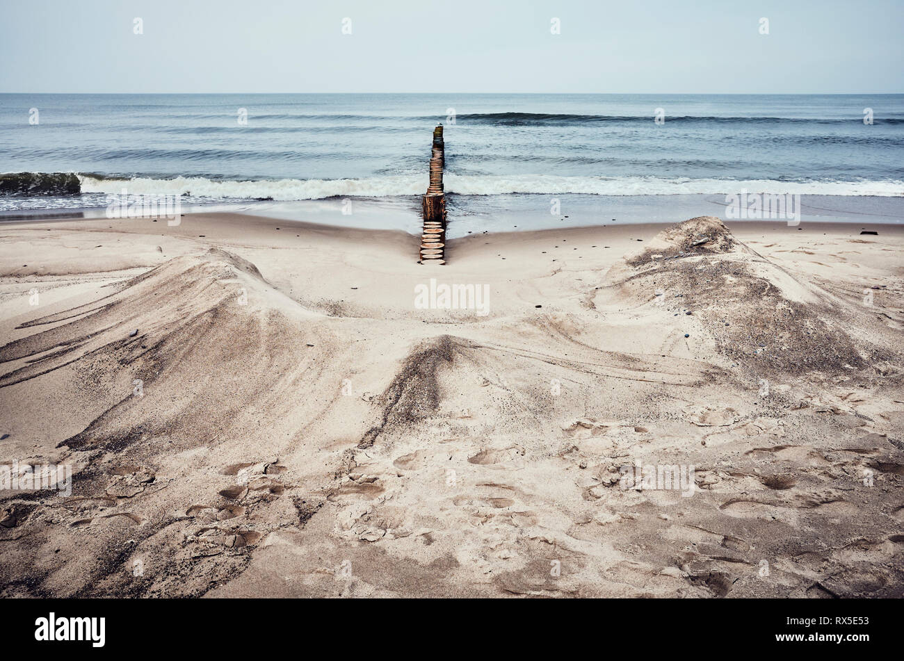 Color toned picture of a sandy beach with wooden groin Stock Photo - Alamy