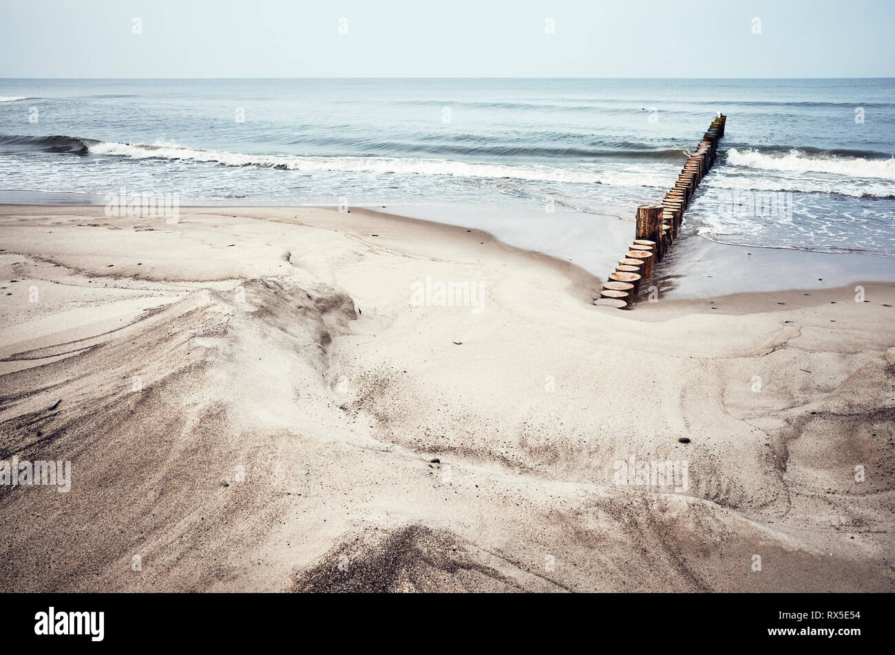 Color toned picture of a sandy beach with wooden groin Stock Photo - Alamy