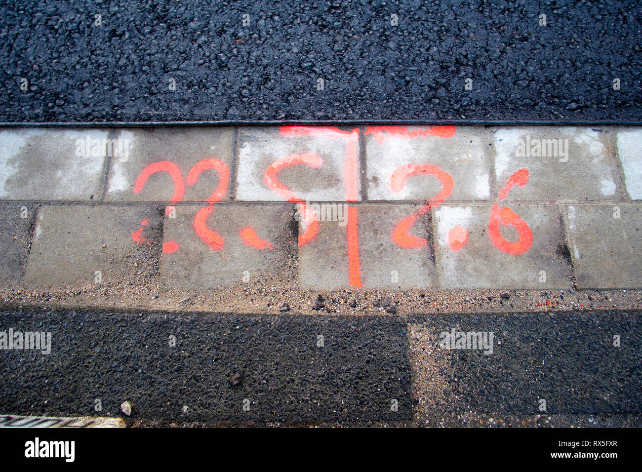 Neu gemachter Bordstein mit einer roten Markierung an neu asphaltierter ...