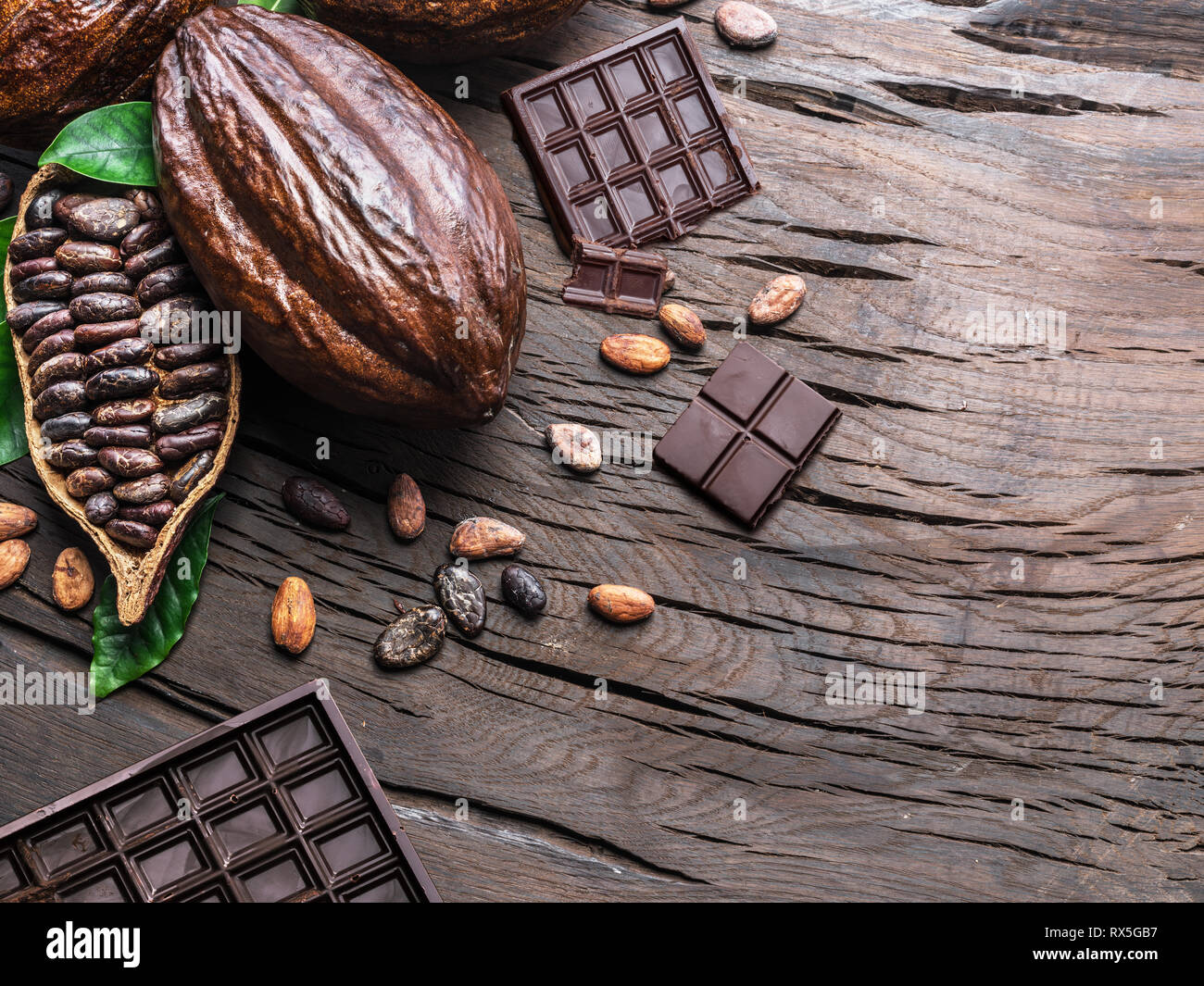 Cocoa pod, cocoa beans and chocolate on the wooden table. Top view ...