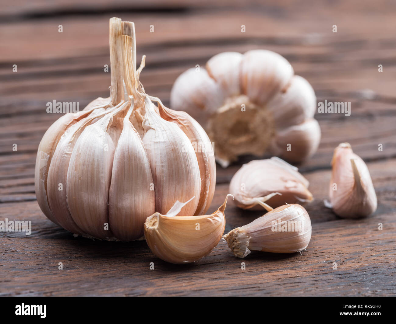 Garlic bulb and garlic cloves on the wooden table Stock Photo - Alamy