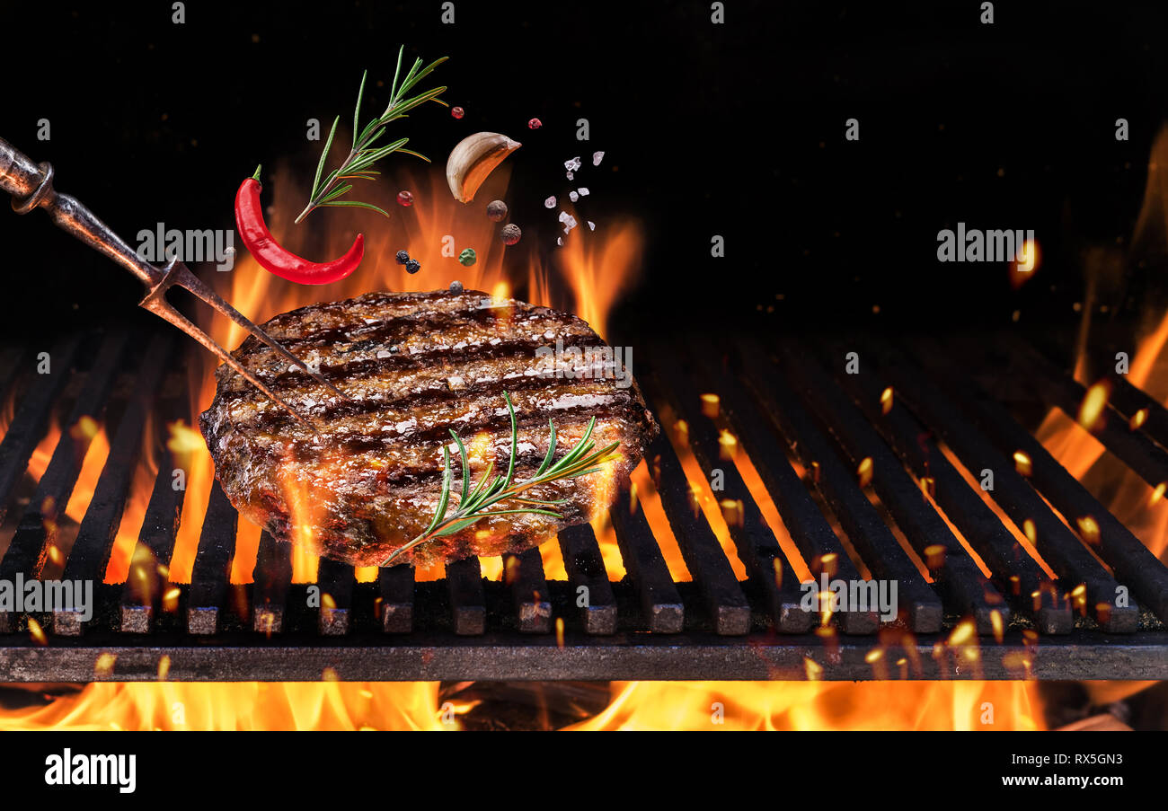 Beef milled meat on hamburger with spices fly over the flaming grill ...