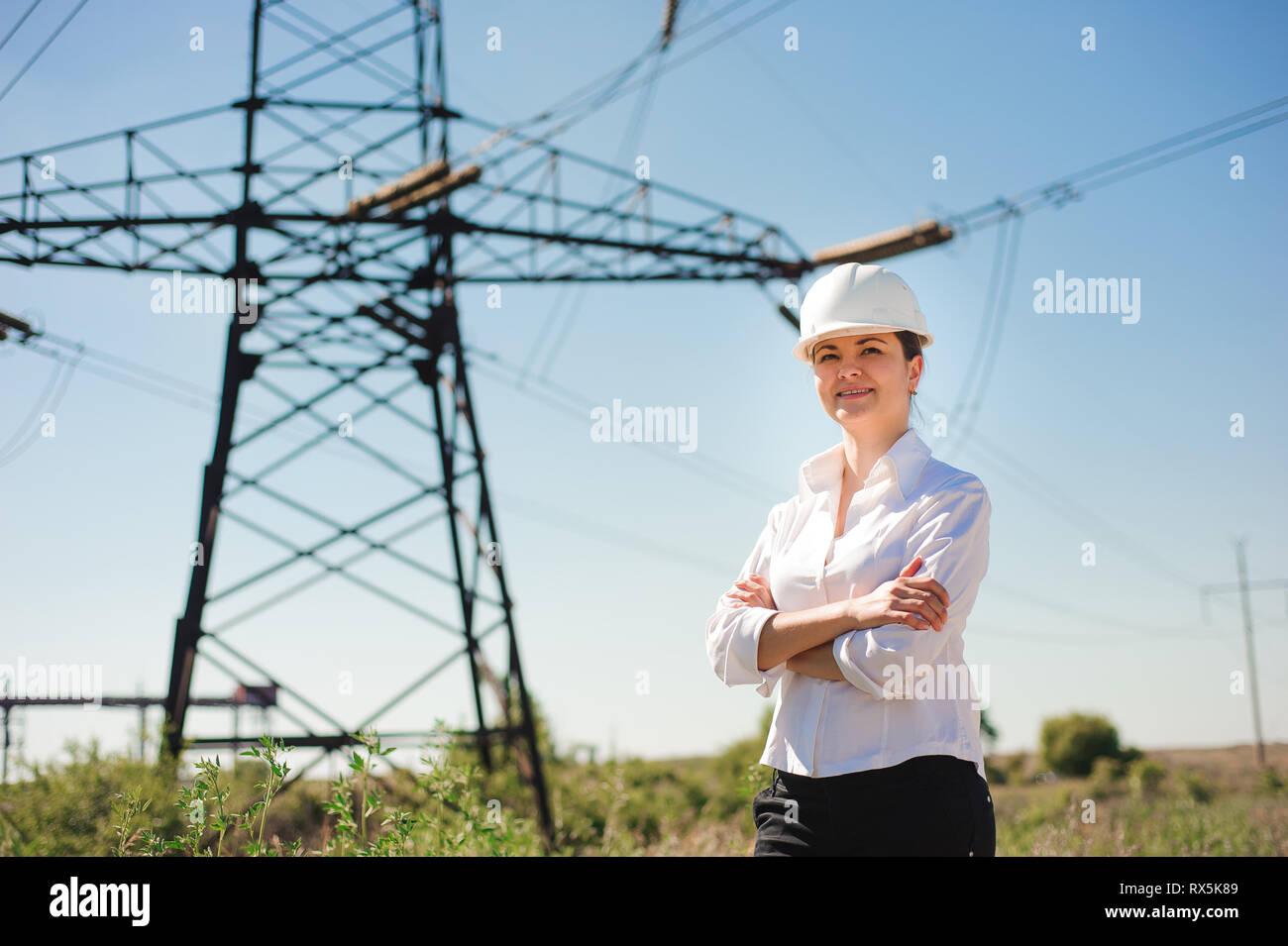 Engineer with white hard hat under the power lines. Engineer work at an ...