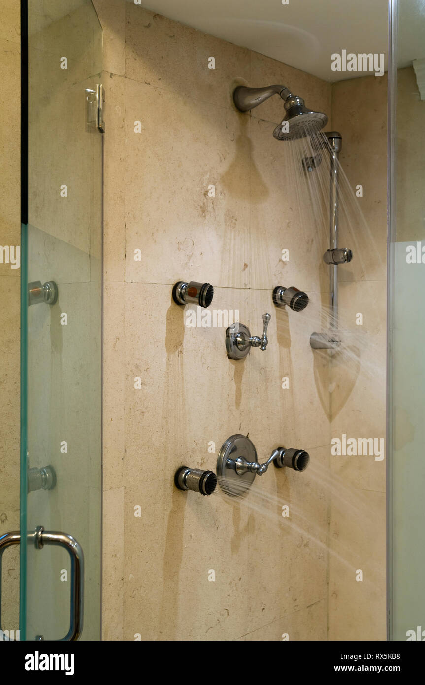 Running shower with brown tiles Stock Photo - Alamy