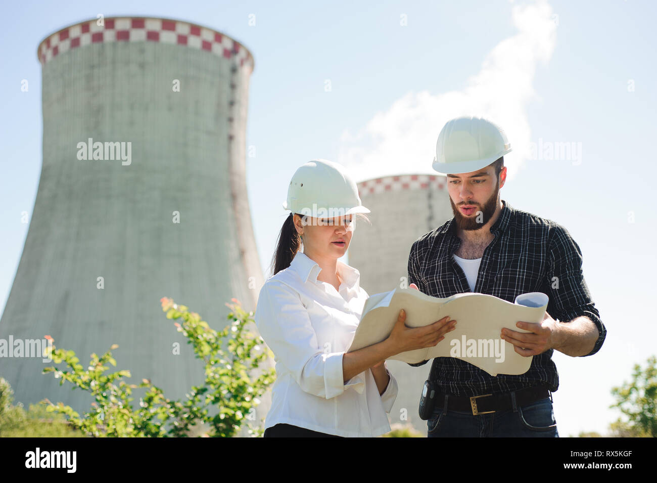 two engineers standing at electricity station, discussing plan Stock ...
